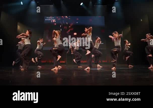 A group of children performs a dynamic dance routine on a stage with ...