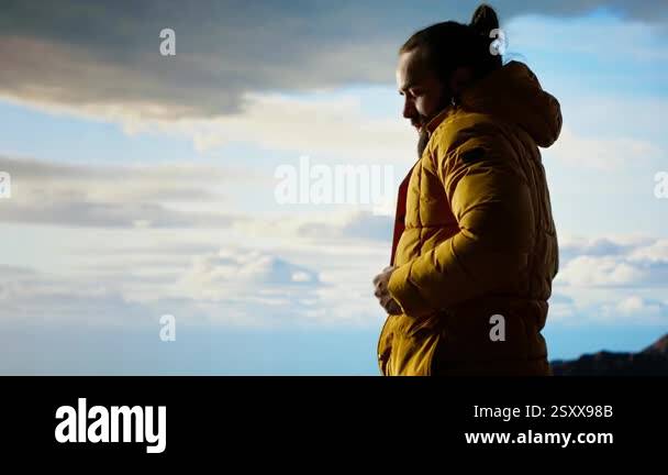 Male trekker takes in the breathtaking mountain landscape on rocks ...