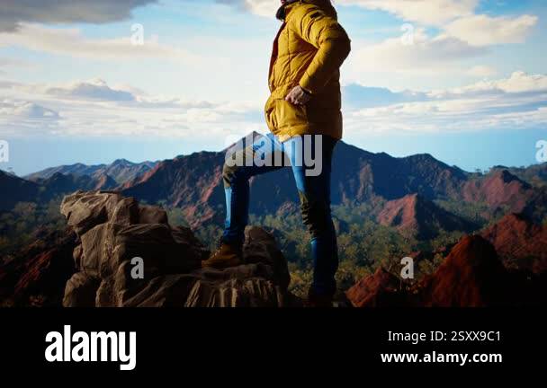 Male trekker takes in the breathtaking mountain landscape on rocks ...