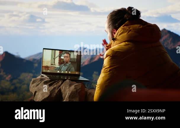 Young CEO entering a video call from the mountain top with a strong ...