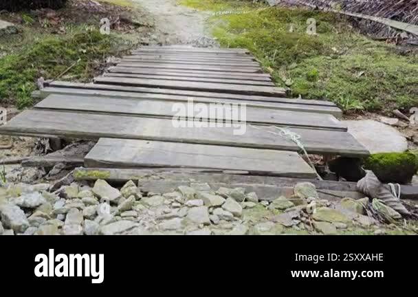 a simple short wooden bridge pathway at the plantation drainage ...