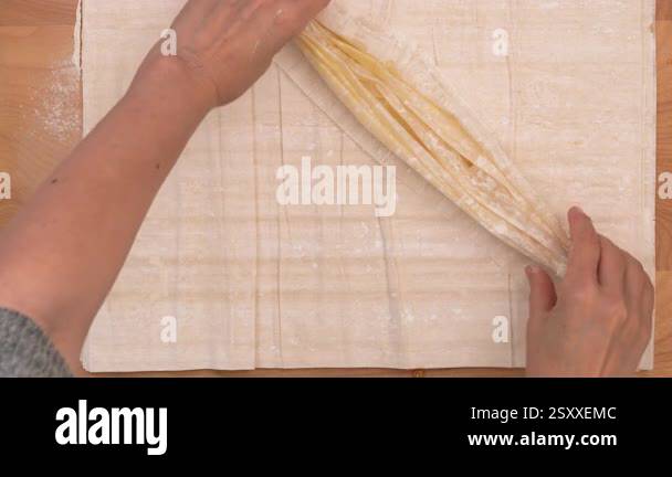 Chef folding buttered layers of phyllo dough into rolls. High quality ...