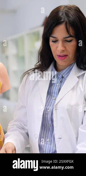 Female professor explaining human anatomy through detailed anatomical ...