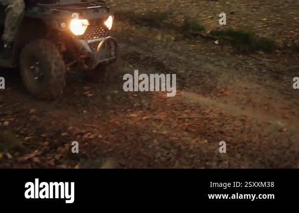 Muddy trail, ATV adventure, Helmet journey. Individual in camo clothing ...