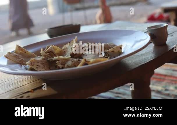 Traditional bedouin woman gently picking pieces of freshly baked ...