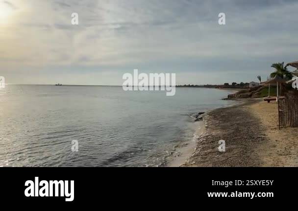 Bright sunlight reflecting over turquoise waters, red sea shoreline ...