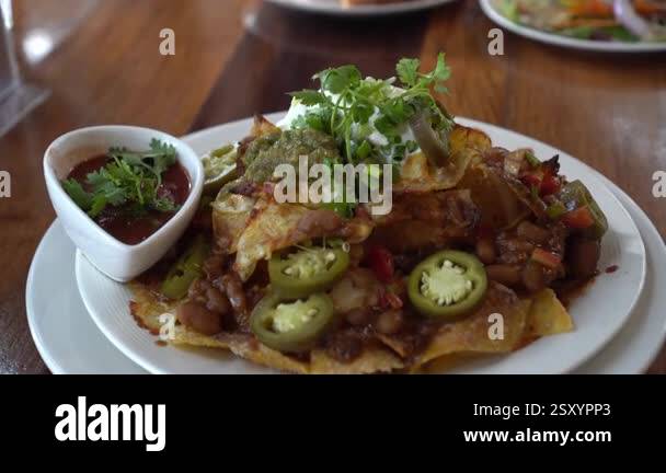Picking cheesy nacho chips with salsa and minced meat dipping Mexican ...