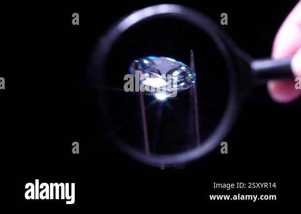 Goldsmith hands inspect the quality of luxury brilliant diamond with ...