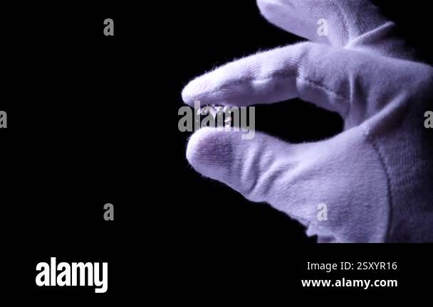 Goldsmith hands in white gloves inspect the quality of luxury brilliant ...
