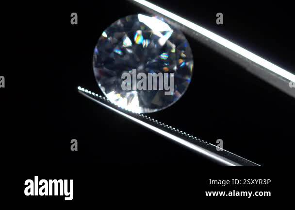 Hand held in tweezers diamond quality Inspection, selective focus ...