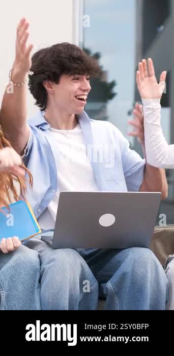 Students celebrate success while using a laptop, expressing happiness ...