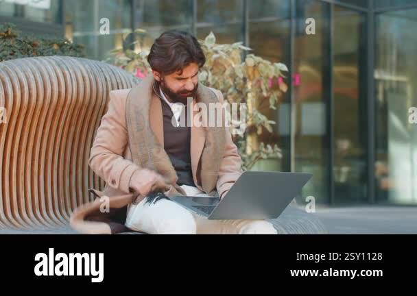 Sad Arabian man tourist using laptop computer typing browsing, loses ...