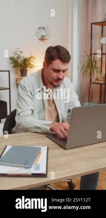 Angry furious man freelancer using laptop while working at home office ...