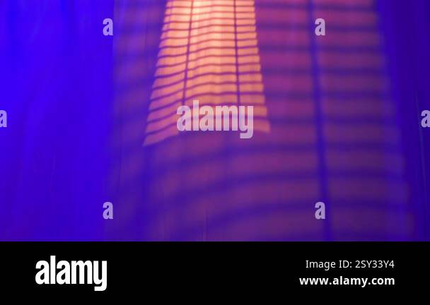 Windows with colorful tulle fabrics blown by the wind. Transparent silk ...