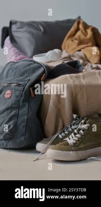 No people vertical closeup of backpack, pair of khaki trainers on floor ...