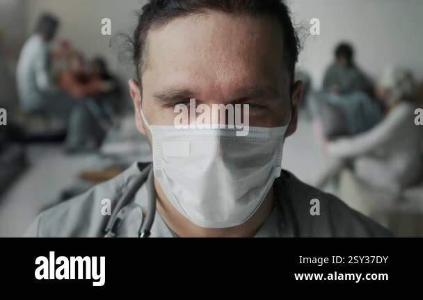 Closeup portrait of young Caucasian male nurse in blue uniform, with ...
