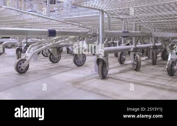Close-up view of shopping cart wheels and peoples feet navigating the ...
