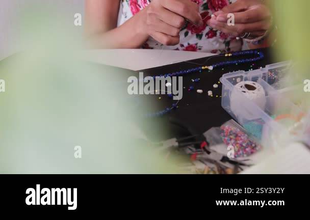 A small business owner designing and crafting unique handmade jewelry ...