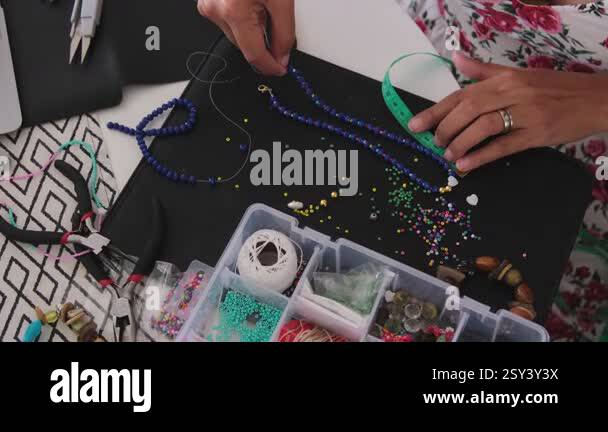 A small business owner designing and crafting unique handmade jewelry ...