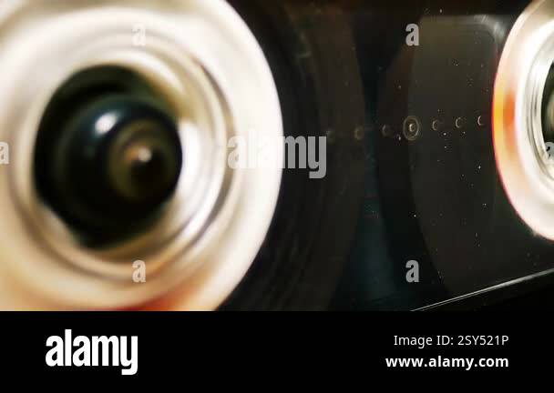 Audio cassette in close-up; Audio cassette in the tape recorder playing ...
