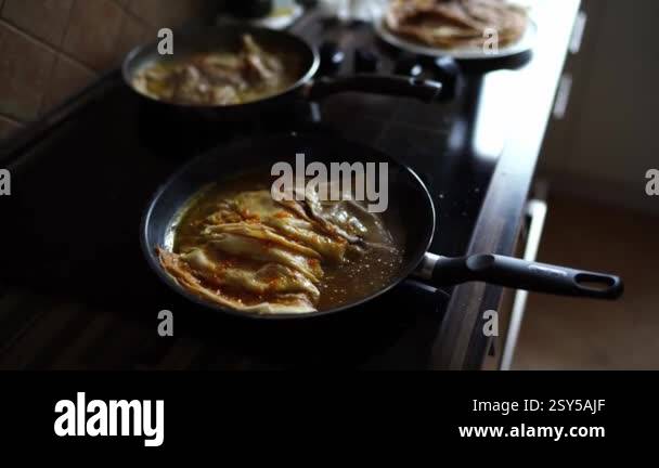 Cook shakes a frying pan with burning fire crepe suzette in sweet sauce ...