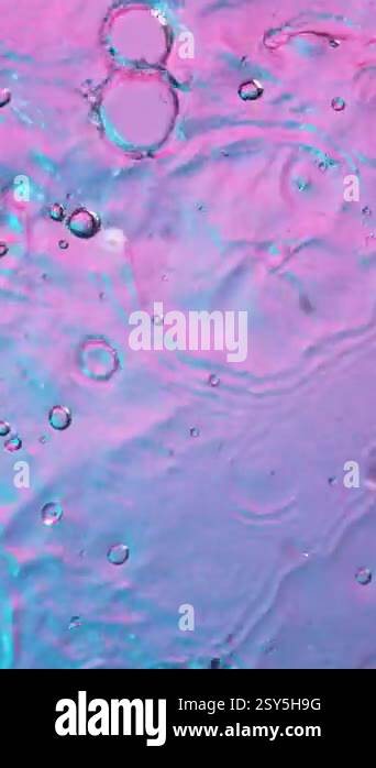 Super slow motion of splashing water wave illuminated by neon lights ...
