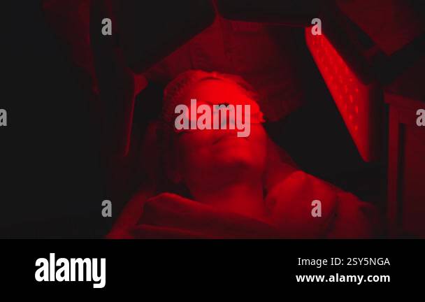 A person enjoys a calming red light therapy treatment while lying ...