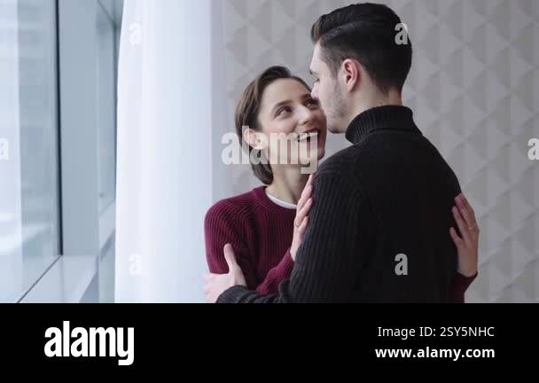 Two individuals share a happy interaction while standing close together ...