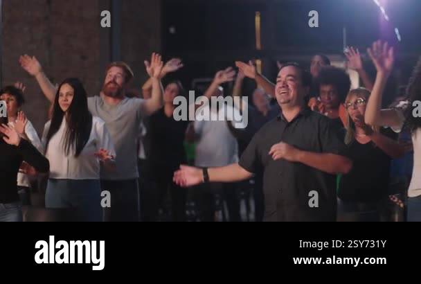 Men and women raising hands in uplifting worship session, joyful ...