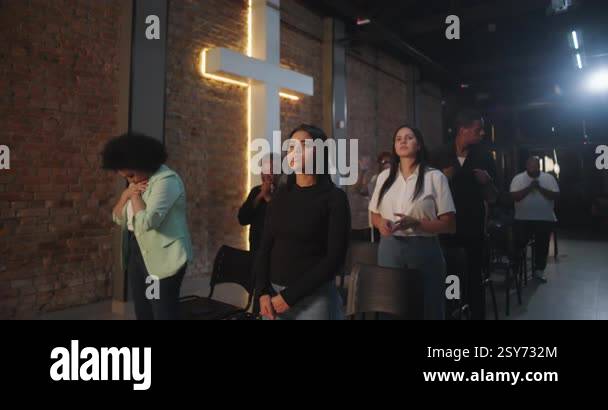 Diverse group of people worshipping in church, emotional praise and ...