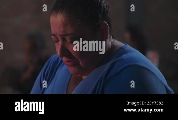 Woman in deep emotional reflection with closed eyes, hands pressed ...