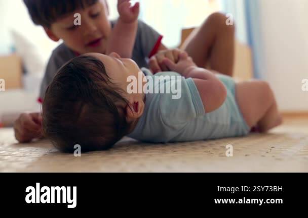 Baby lying on mat, moving hands and feet, active infant play, early ...