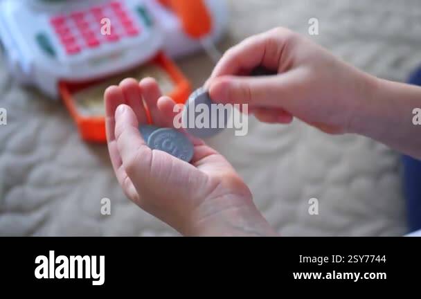 A child's hand, full of play money, ready to make a purchase. Playful ...