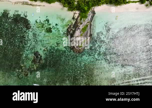 Prominent rock formation with surrounding turquoise water and visible ...