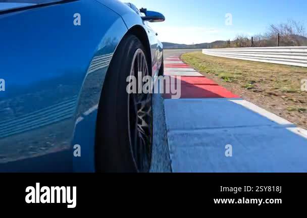LOW ANGLE, CLOSE UP: Metallic blue sports car racing on a closed ...