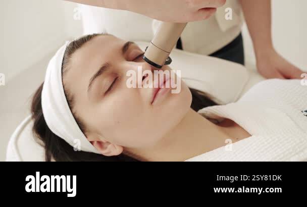 Close up of a young girl getting laser face treatment in a medical ...