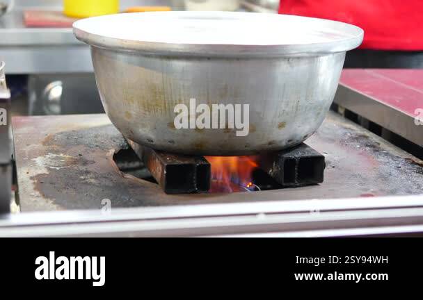 A pot simmers on the stove, flames dancing beneath it Stock Video ...