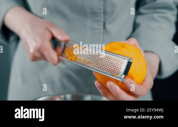 A stunning closeup of hands expertly grating an orange, showcasing its ...