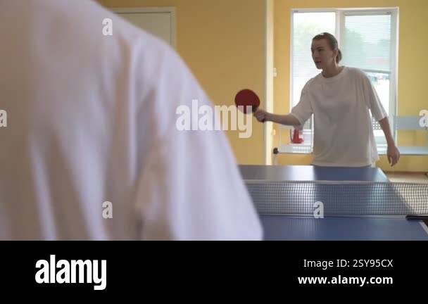 Two people playing table tennis. Man and woman compete in ping pong ...