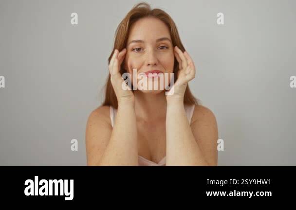 Woman touching face with closed eyes against white background exuding ...