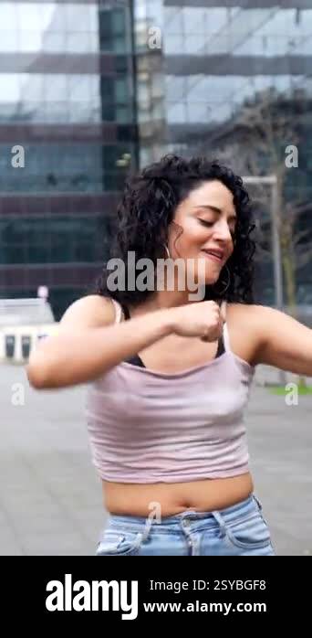 Curly haired female dancer performing freestyle movement, expressing ...