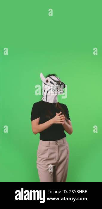 Real time anonymous female with long hair and wearing zebra head mask ...