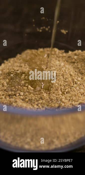 Chopped Nuts and honey. Honey pouring on walnuts in bowl, close-up ...