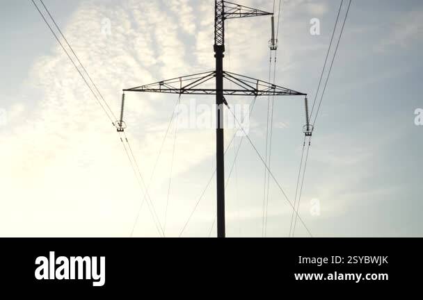 A high voltage power line tower stands tall against a backdrop of a ...