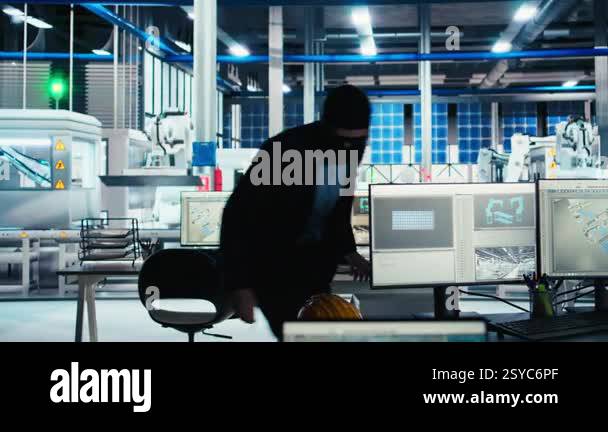 Hacker sneaking into solar panel facility, inserting USB stick into PC ...