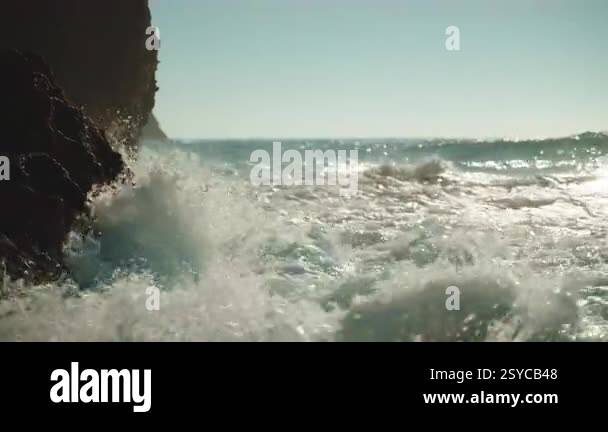 Huge ocean waves crashing on rocks. Wild seascape with sea foamy big waves in windy sunny ...