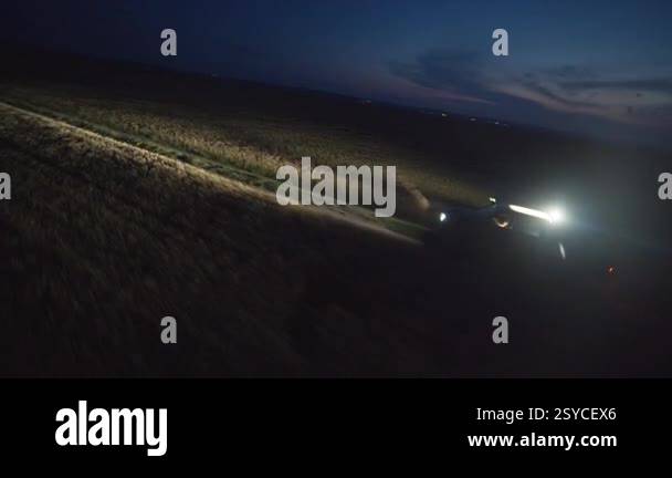 Footage from drone of fast car with highlights driving by straight ...