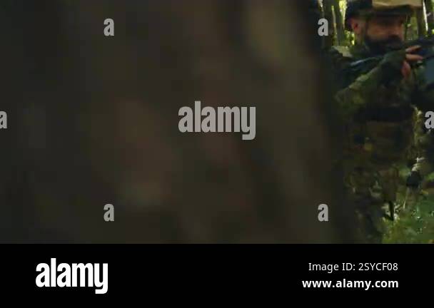 Footage of male and female soldiers with guns moving through forest ...