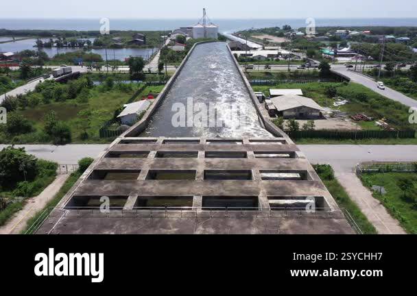 An elevated canal above the road is draining water into the sea Stock ...