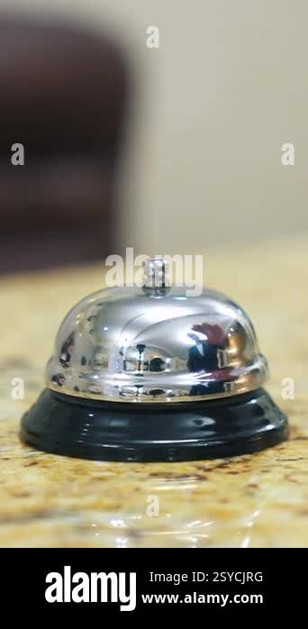 Hotel bell button on customer reception counter. The hand of the man ...